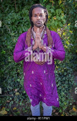 Posed portrait of a Hindu young man in blue dressed as the God Shiva ...