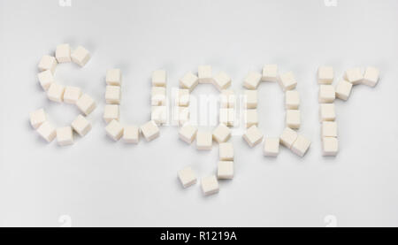 the word sugar is made up of sugar cubes on a red background. photo on ...