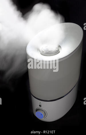 Humidifier spreading steam in a dark room Stock Photo - Alamy