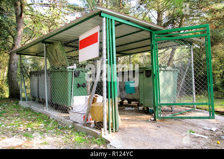 Garbage containers in fence cage / Orderly stowed garbage cans for ...