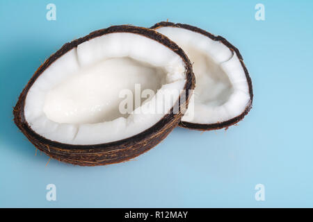 Crash coconut on a blue background close-up Stock Photo - Alamy