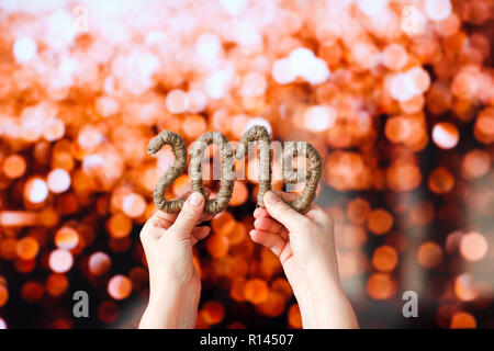 2019 numbers in hands and bokeh background. Christmas and happy new ...