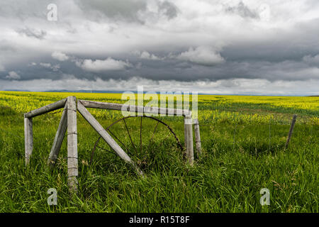 Old fence and field against a dramatic sky in southern Alberta, Canada ...