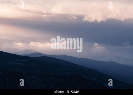 Dramatic winter storm blows over a cold barren landscape near sunset ...