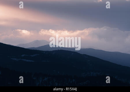 Dramatic winter storm blows over a cold barren landscape near sunset ...