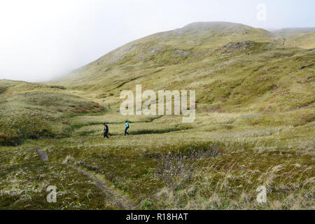Two indigenous Unangan (Aleut) youth hiking along an ancient trail to ...