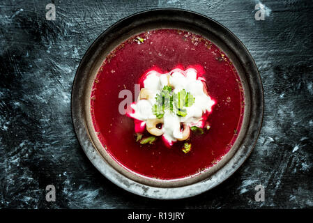 Bowl with tasty borscht, sour cream and green onion on light background ...