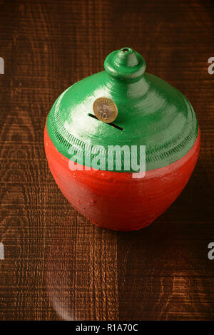 Money-saving bank, Gold Gullak gulak coin box in between of many black ...