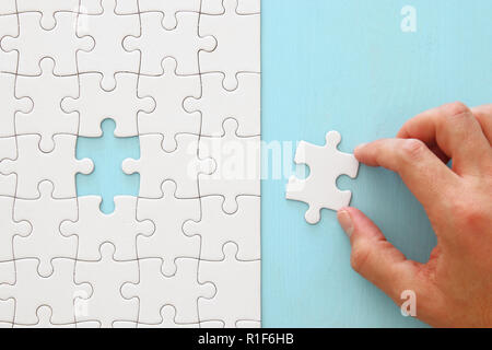 male hand putting the last piece in the puzzle Stock Photo - Alamy