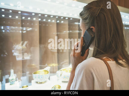Woman in museum with handheld audio guide device Stock Photo - Alamy