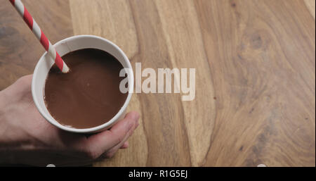 Cocoa with red striped paper straw on wood background with copy space ...