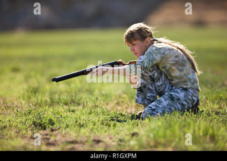Girl crouching with hunting rifle Stock Photo - Alamy