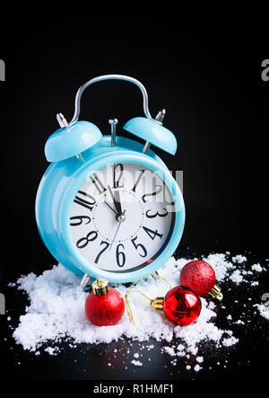 Alarm clock with festive decorations on blue background. Christmas ...