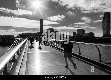 A man jogging and people walking over the Millennium Bridge (wobbly ...