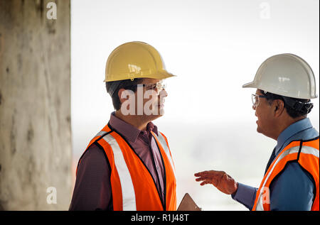Construction worker and executives talking on construction site Stock ...