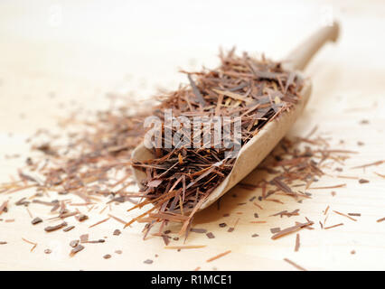 Lapacho herbal tea portion lying on the wooden spoon on mat, pile of ...