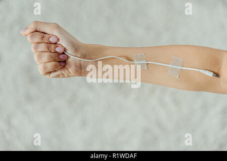 Close up of intravenous line attached to patient hand in hospital bed ...