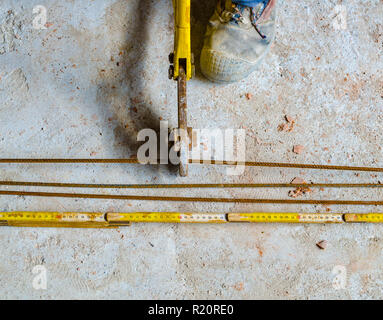 Worker is cutting reinforcement mesh with bolt cutters at building site ...