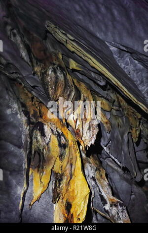 Rock formations of grey limestone with speleogens and reddish ...
