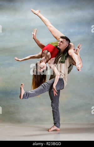 Two people dancing in contemporary stile of ballet at studio on gray ...