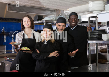 Woman waiter with kitcheners are standing together on kitchen Stock ...