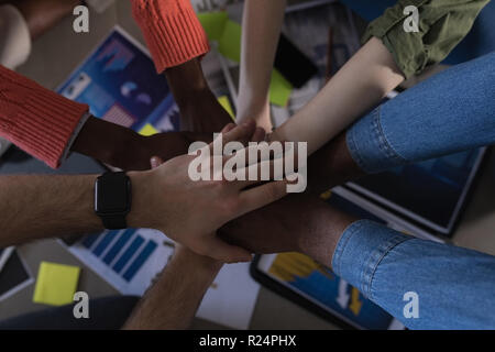 Close-up of business executives forming hand stack in futuristic office ...