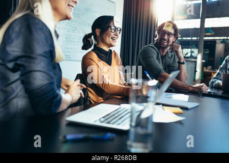 Office workers sitting around conference table Stock Photo - Alamy