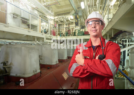Ship's mechanic near marine diesel generators on a merchant ship in the ...