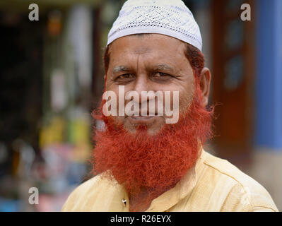 An Indian elderly male with white beard , dressed in yellow clothes in ...