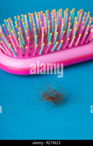 problem with hair. pink comb and drop-down hair on a blue background ...