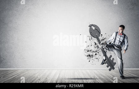Breaking through access concept with man in room crashing concrete key ...