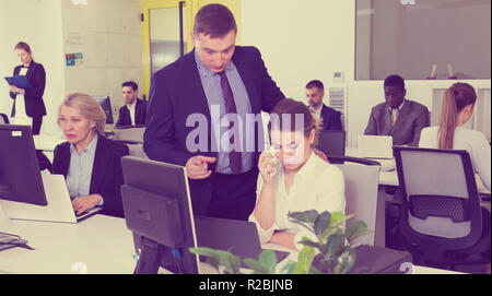 Boss scolding female subordinate pointing out shortcomings and misses ...