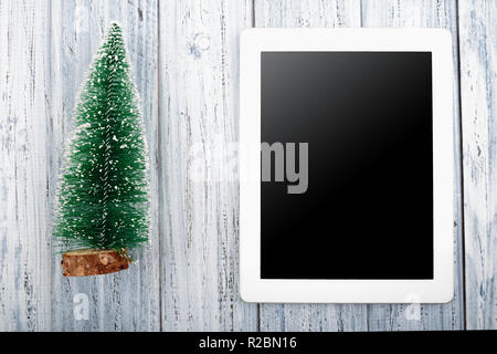 tablet and Christmas tree top view on light grey wooden background. New ...