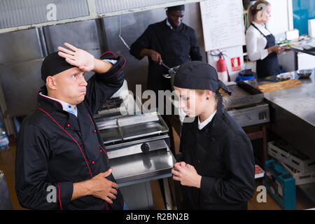 Exasperated chef scolding female employee Stock Photo - Alamy