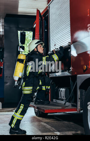 Back side view of firefighter in fire-proof uniform Stock Photo - Alamy