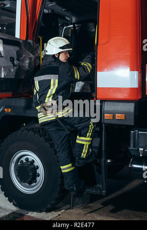 Fireman in fireproof uniform and helmet flexing his biceps Stock Photo ...