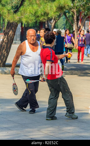 Chinese couple play Jianzi, a sport game in which players keep a ...
