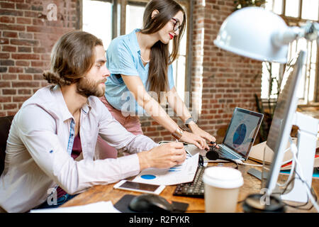 Young couple of colleagues dressed casually working together with ...