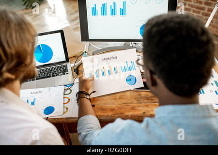 Coworkers working with analitycs sitting together at the working place ...