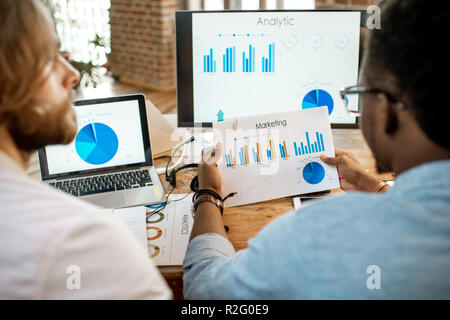 Coworkers working with analitycs sitting together at the working place ...