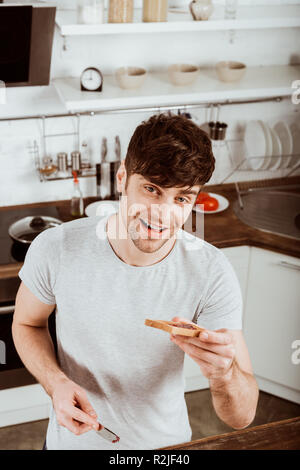 Man eating jam on toast Stock Photo - Alamy
