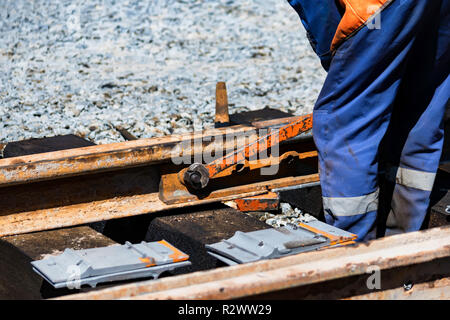 Worker tightens the skrew in railway or tram tracks Stock Photo - Alamy