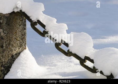 Metal bollard with chain link fence Stock Photo - Alamy
