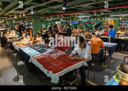 Vendors sit behind their booths at the Jianguo Holiday Jade Market in ...