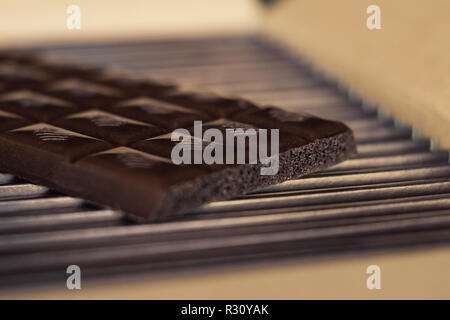 Tiles of dark chocolate on a cardboard box packed with chocolate. Close ...