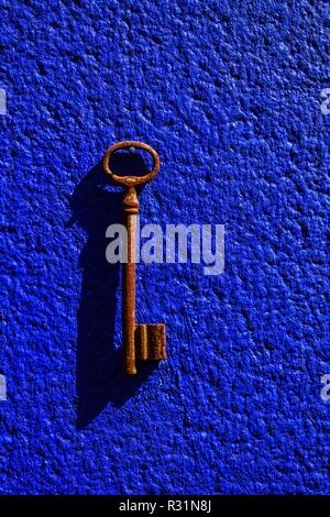 Rusty brass key on the blue wall Stock Photo - Alamy