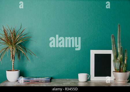 Plants, photo frame and journals on green background Stock Photo - Alamy