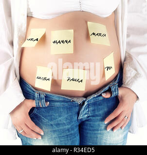 Baby names, belly and sticky notes with pregnant woman in studio on ...