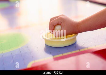 Hand holding a stick to hit disc in the table air hockey game Stock ...