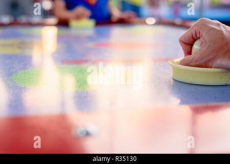 Hand holding a stick to hit disc in the table air hockey game Stock ...